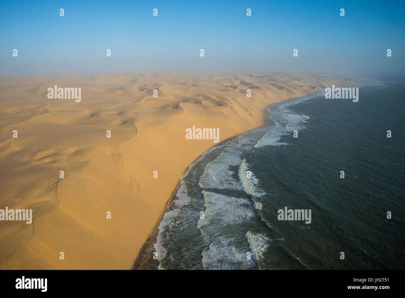Aerials of sand dunes of the Namib Desert meeting the Atlantic Ocean ...
