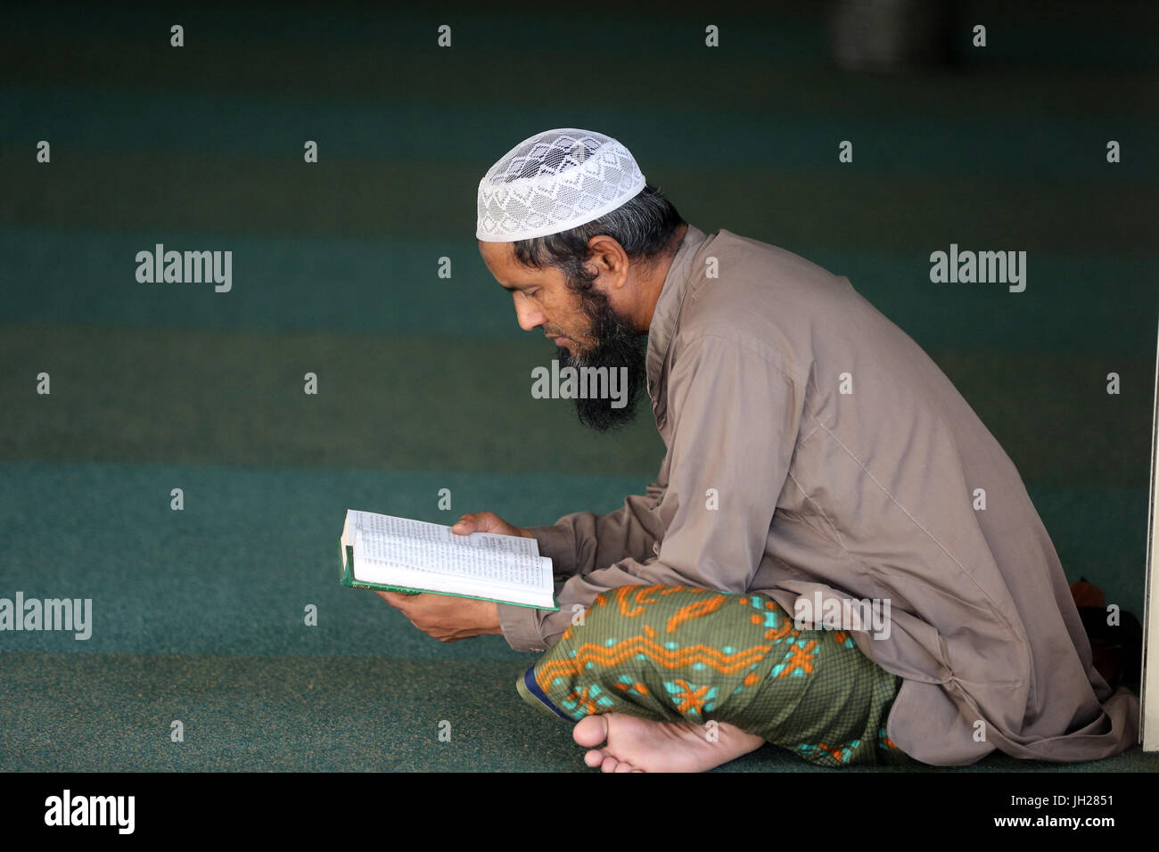 Angullia mosque. Man reading the holy Quran. Singapore Stock Photo - Alamy