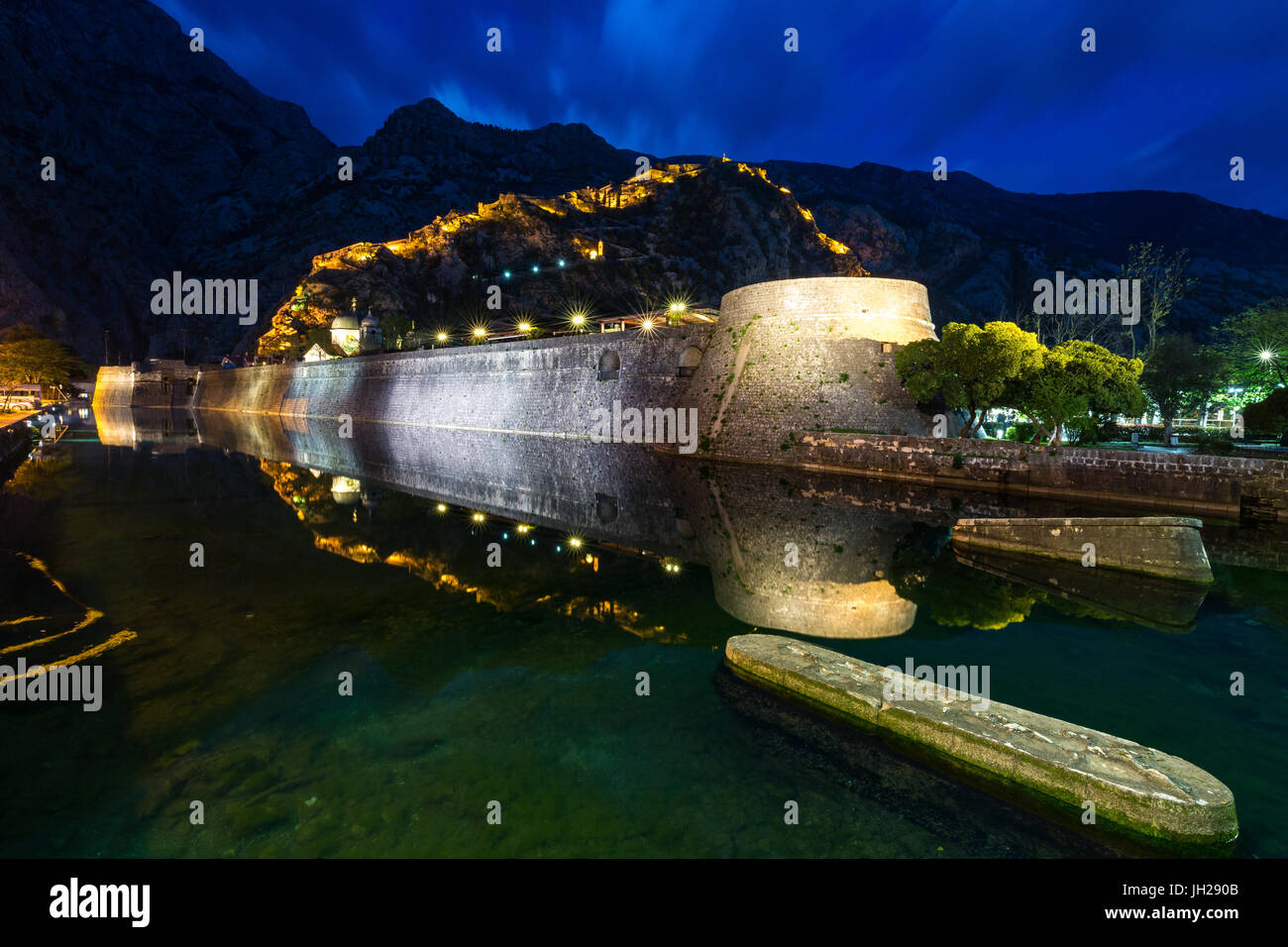 Part of Kotor's old town wall and lit fortress ramparts reflected ...