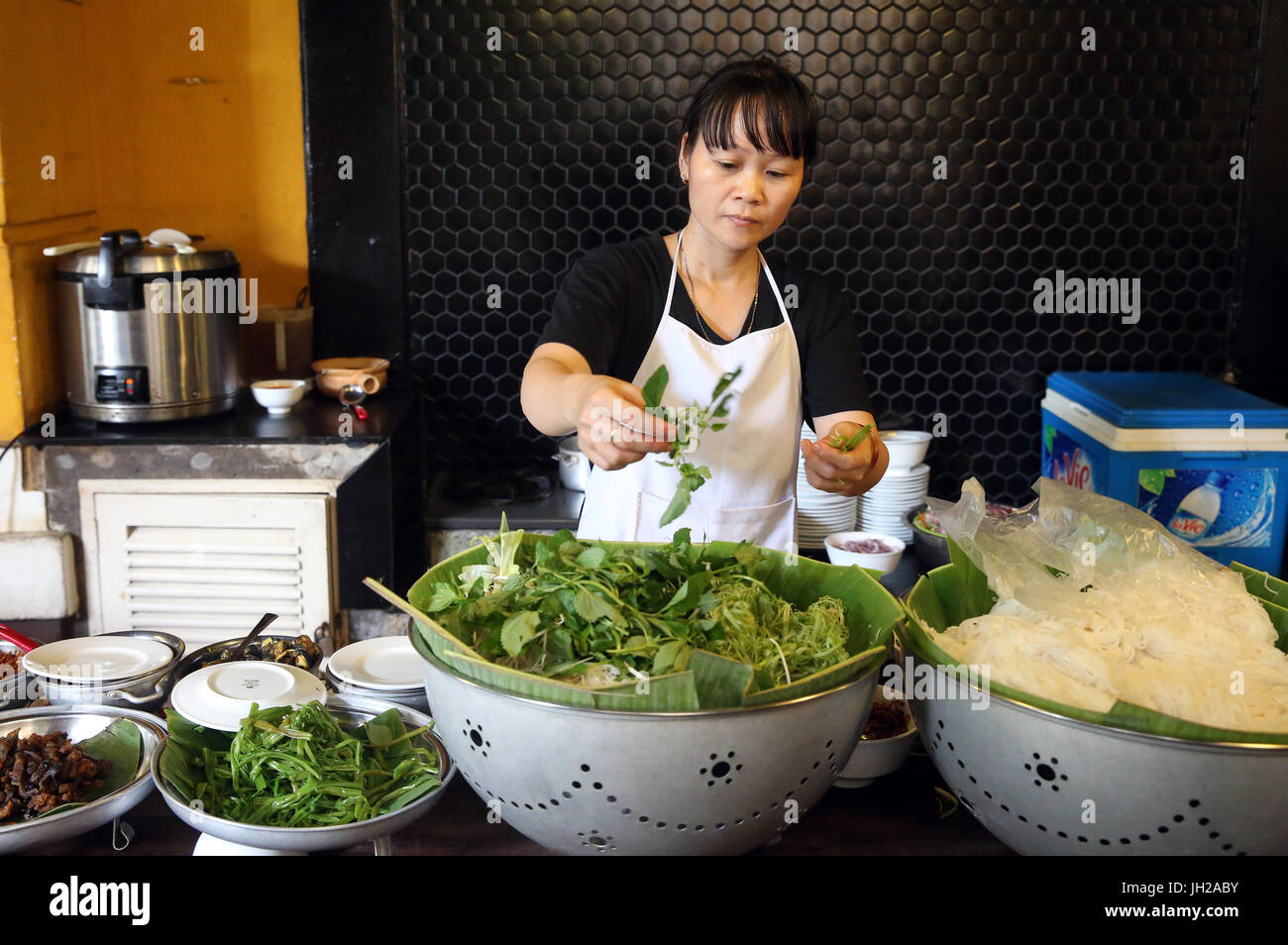 Vietnamese restaurant. Woman working in the kitchen. Ho Chi Minh City ...