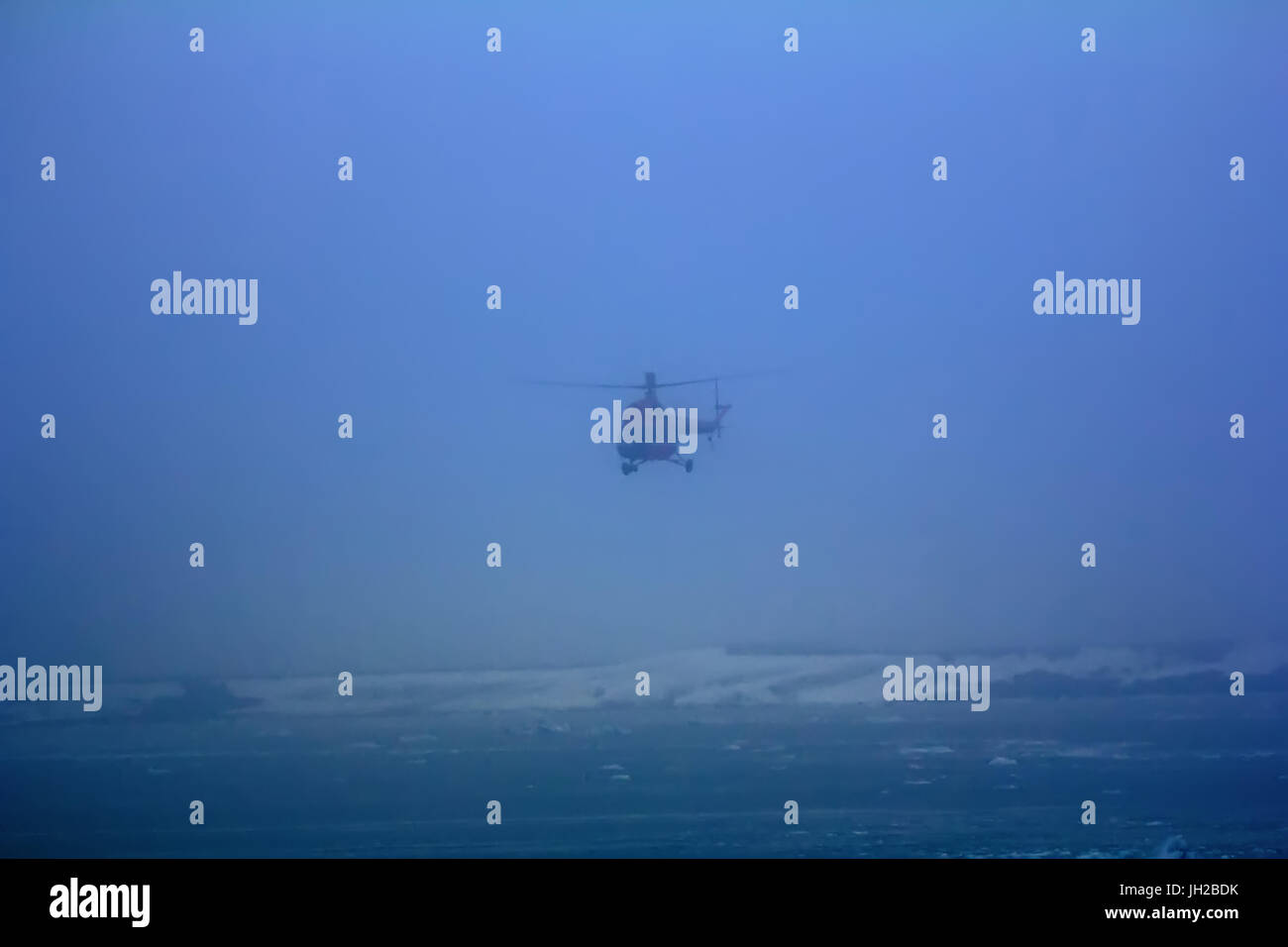 Helicopter with glaciologists and tourists-extreme over clouded Arctic ...