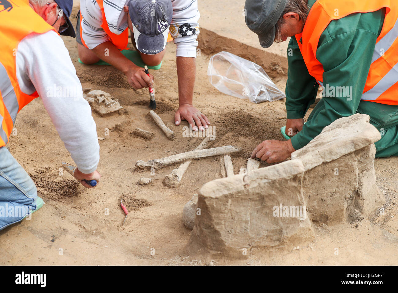 Excavation helpers excavate a skeleton at a grave with stone-aged ...
