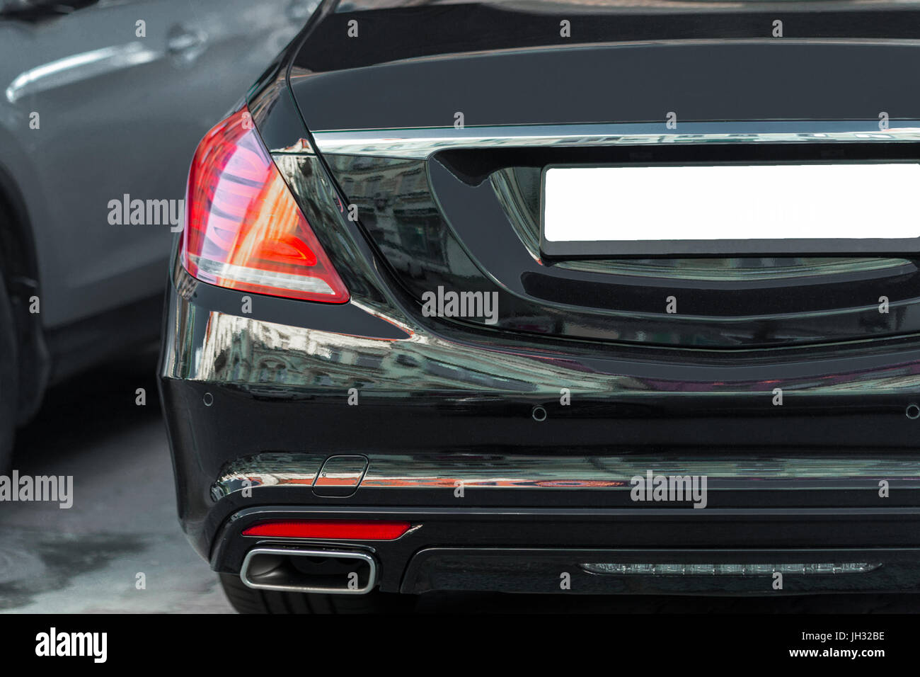 Back view of big luxury expensive sedan car trunk. Black colored. LED ...