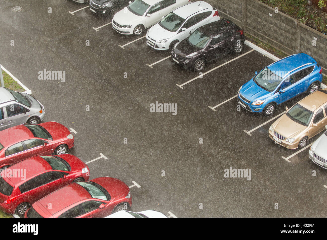Cars parked at a parking lots near high-rise building under heavy ...