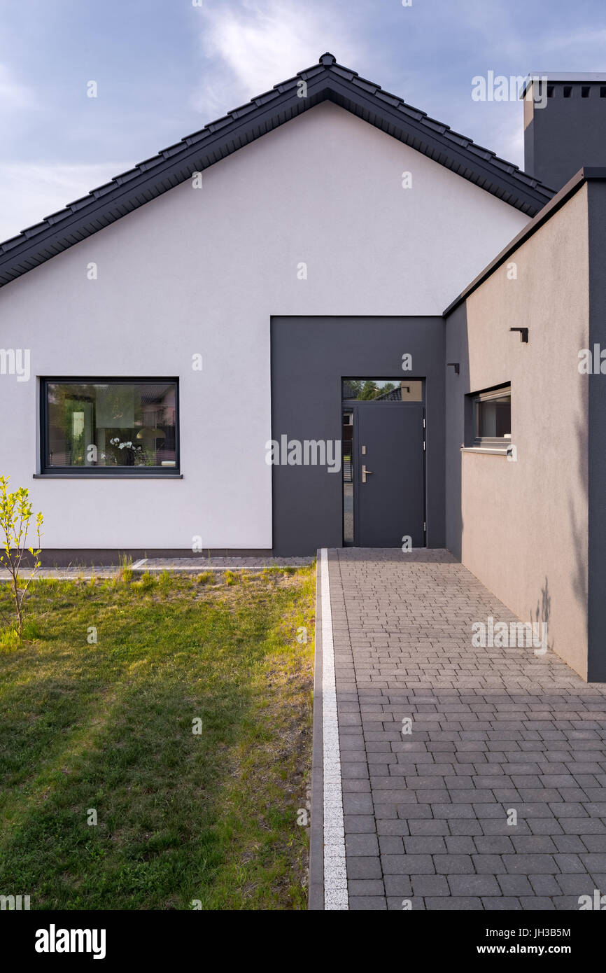 Simple, white house with cobblestone entry pathway, outdoors Stock ...