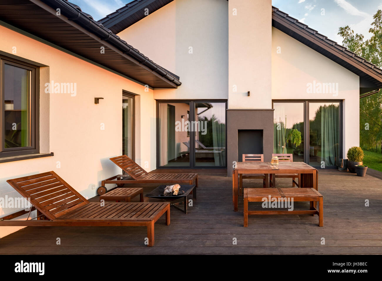 Exterior view of house with patio with wooden furniture Stock Photo - Alamy