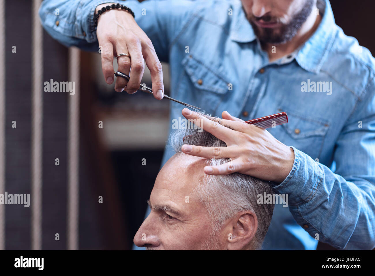Nice handsome barber holding his clients hair Stock Photo - Alamy