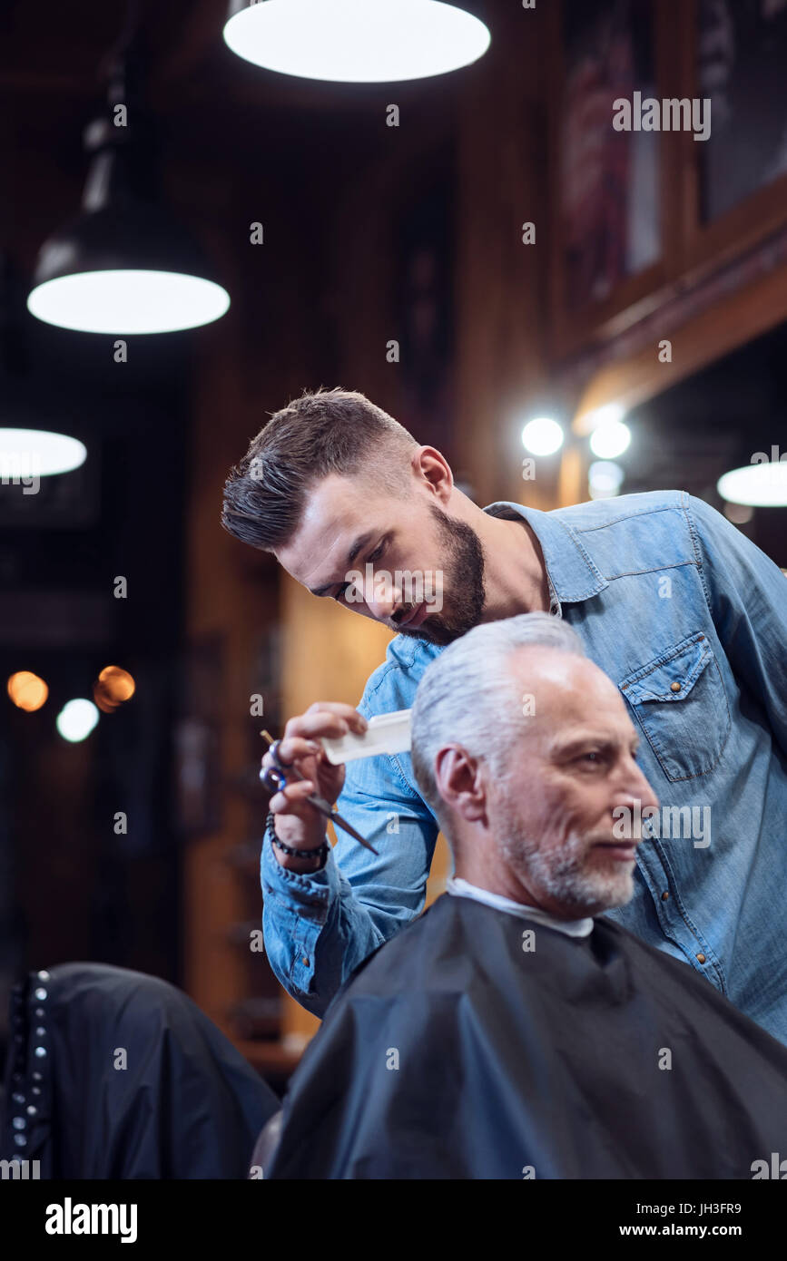 Handsome bearded barber modeling a haircut Stock Photo - Alamy