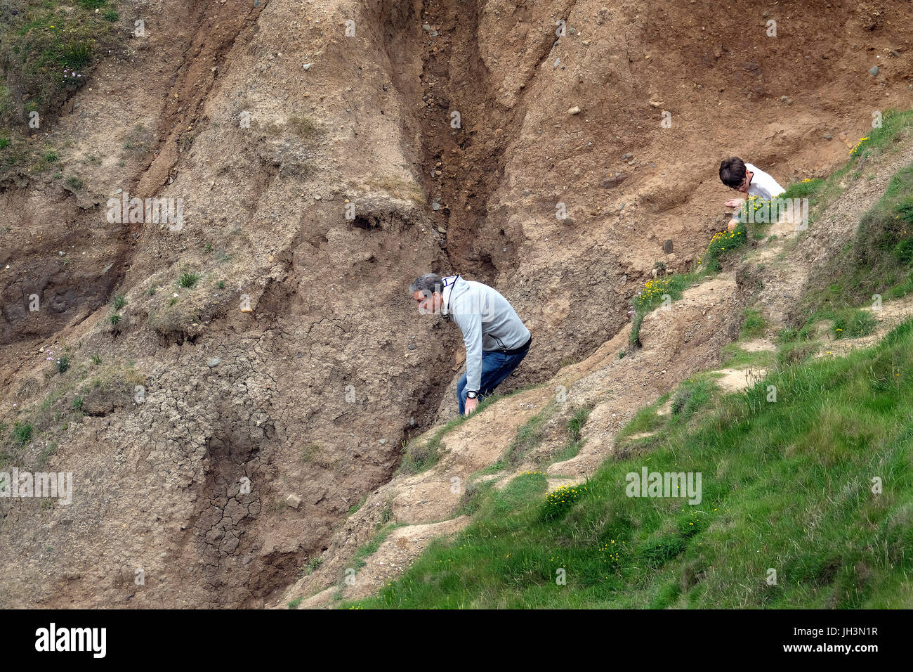 Family climbing down dangerous coastal cliff Stock Photo - Alamy