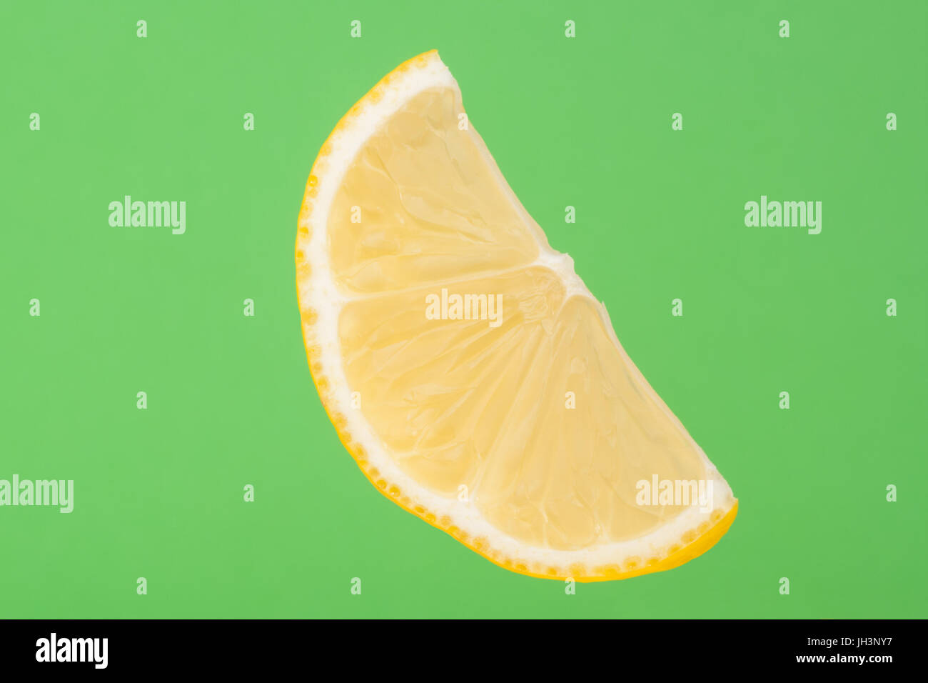 Lemon part on green background. Studio shoot Stock Photo - Alamy