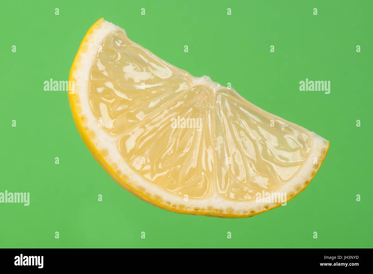 Lemon part on green background. Studio shoot Stock Photo - Alamy