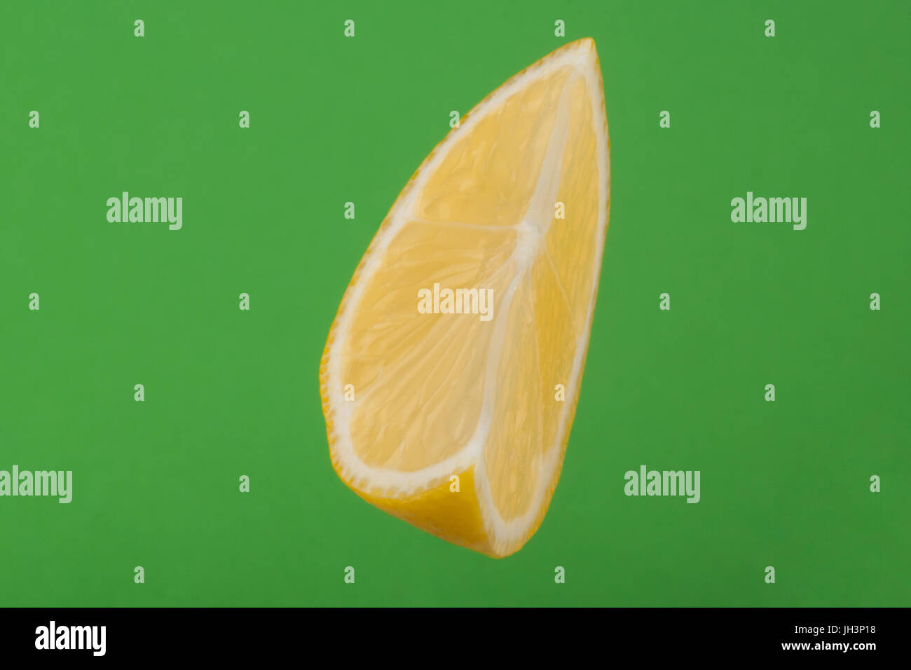 Lemon part on green background. Studio shoot Stock Photo - Alamy