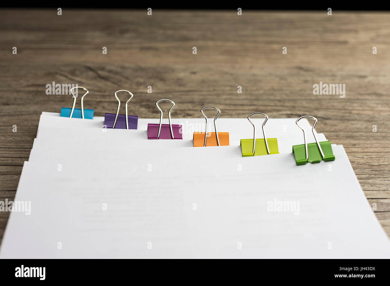 Multiclored paper binders on paperwork close up Stock Photo - Alamy