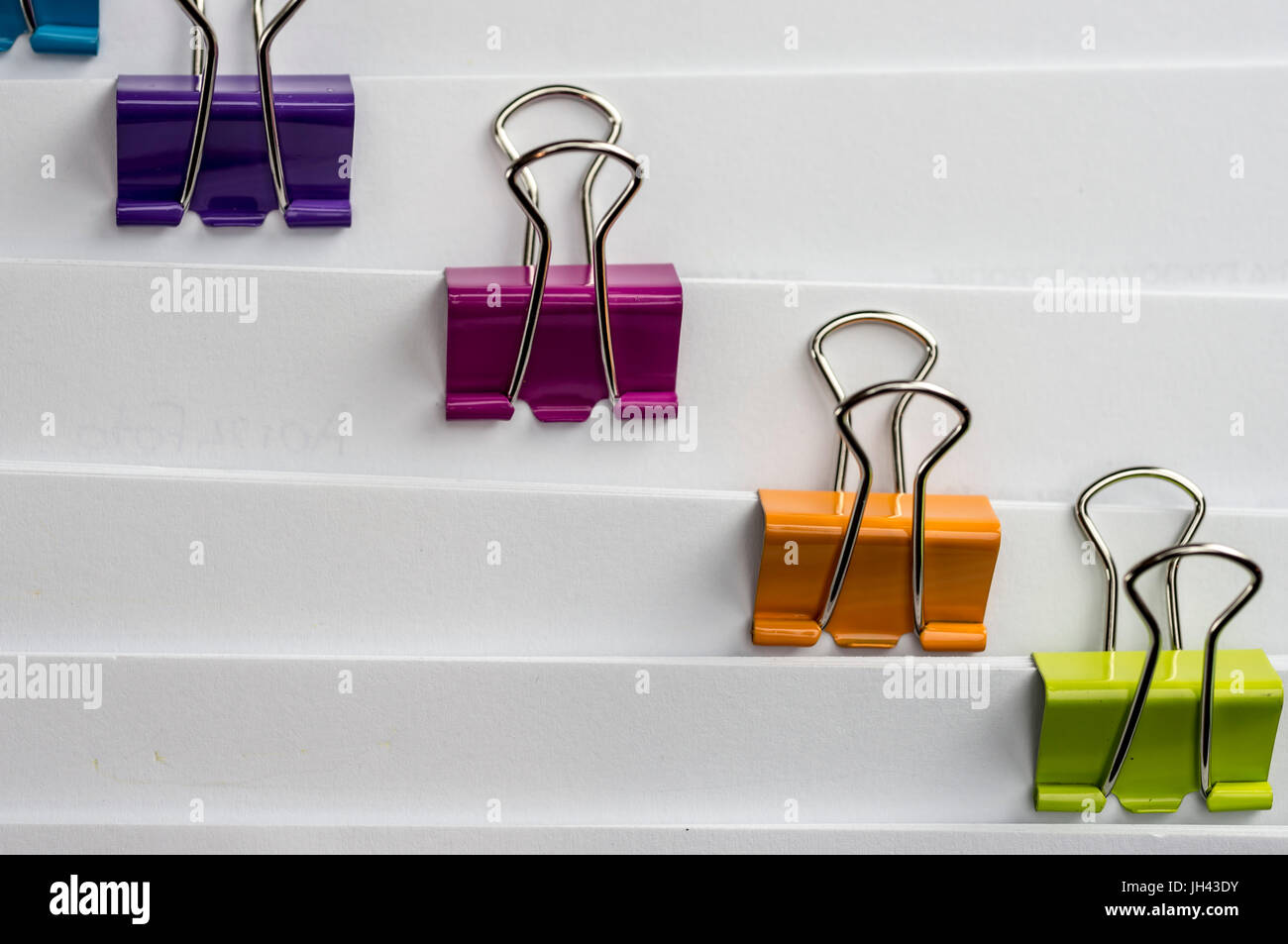 Multiclored paper binders on paperwork close up Stock Photo - Alamy
