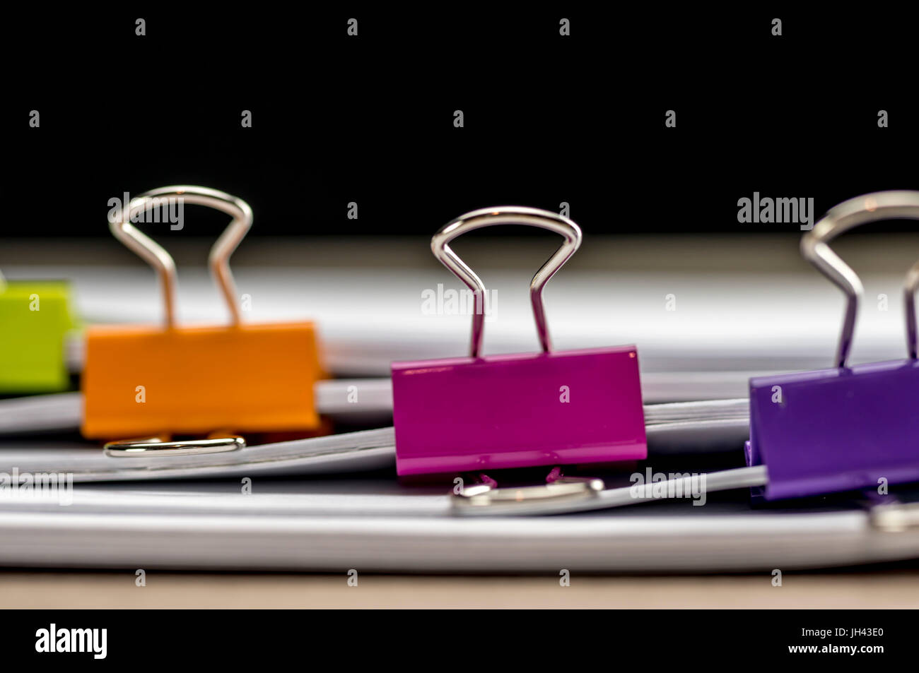 Multiclored paper binders on paperwork close up Stock Photo - Alamy