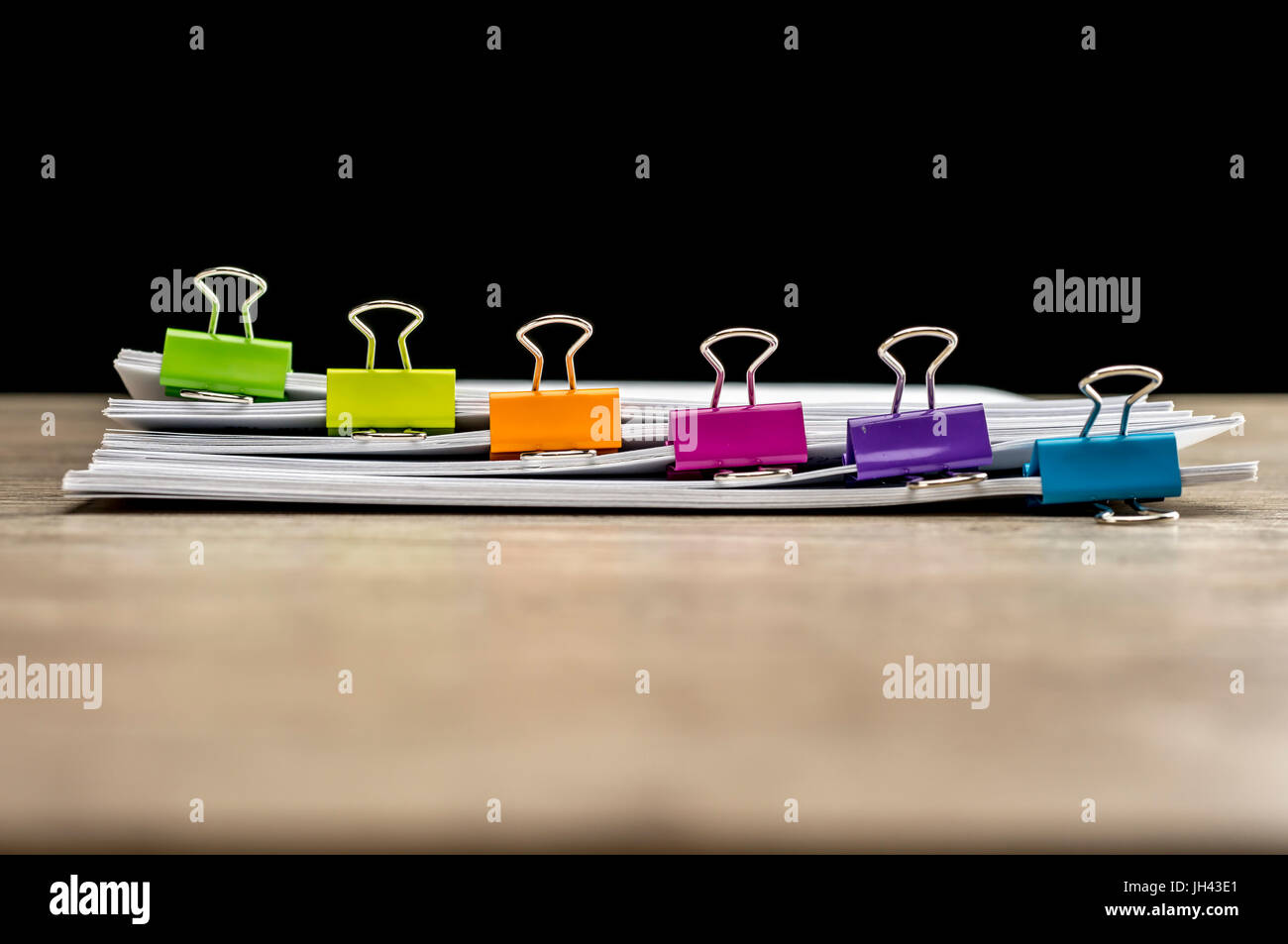 Multiclored paper binders on paperwork close up Stock Photo - Alamy