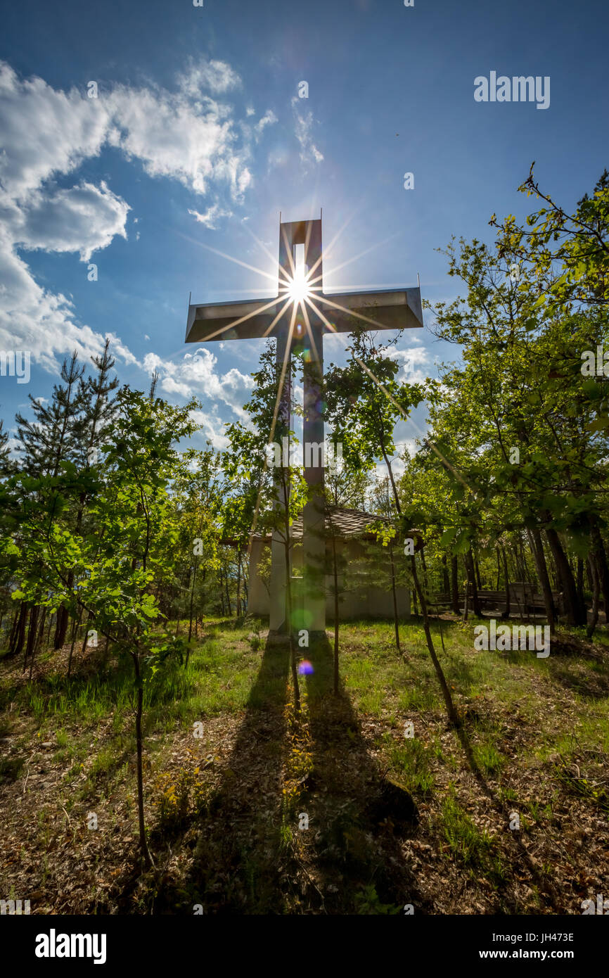 Cross with a Bright Blue Sky and Sun. Diffraction effect. Pine trees ...