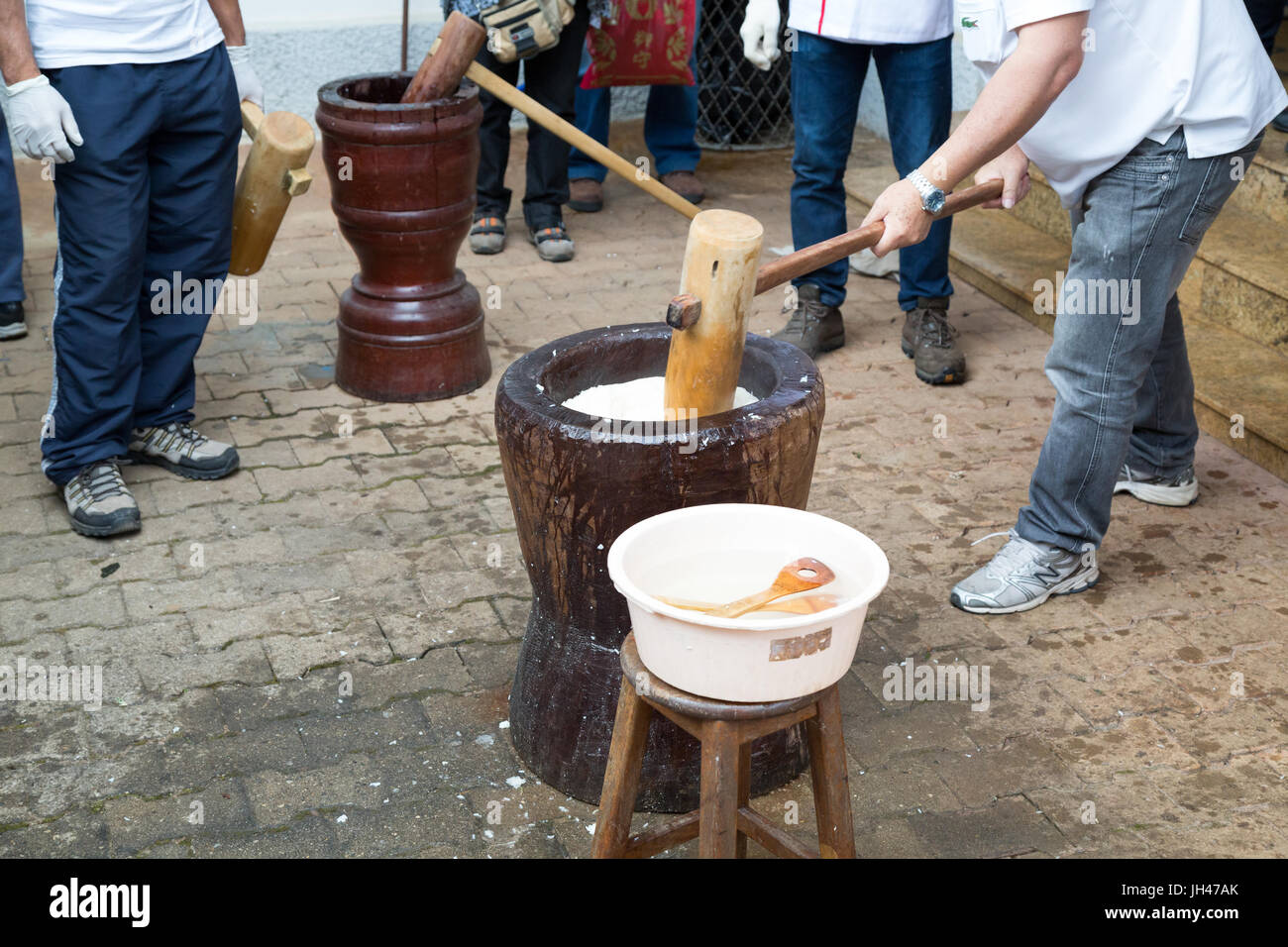 Fresh Japanese mochi being pounded using traditional wooden usu and ...