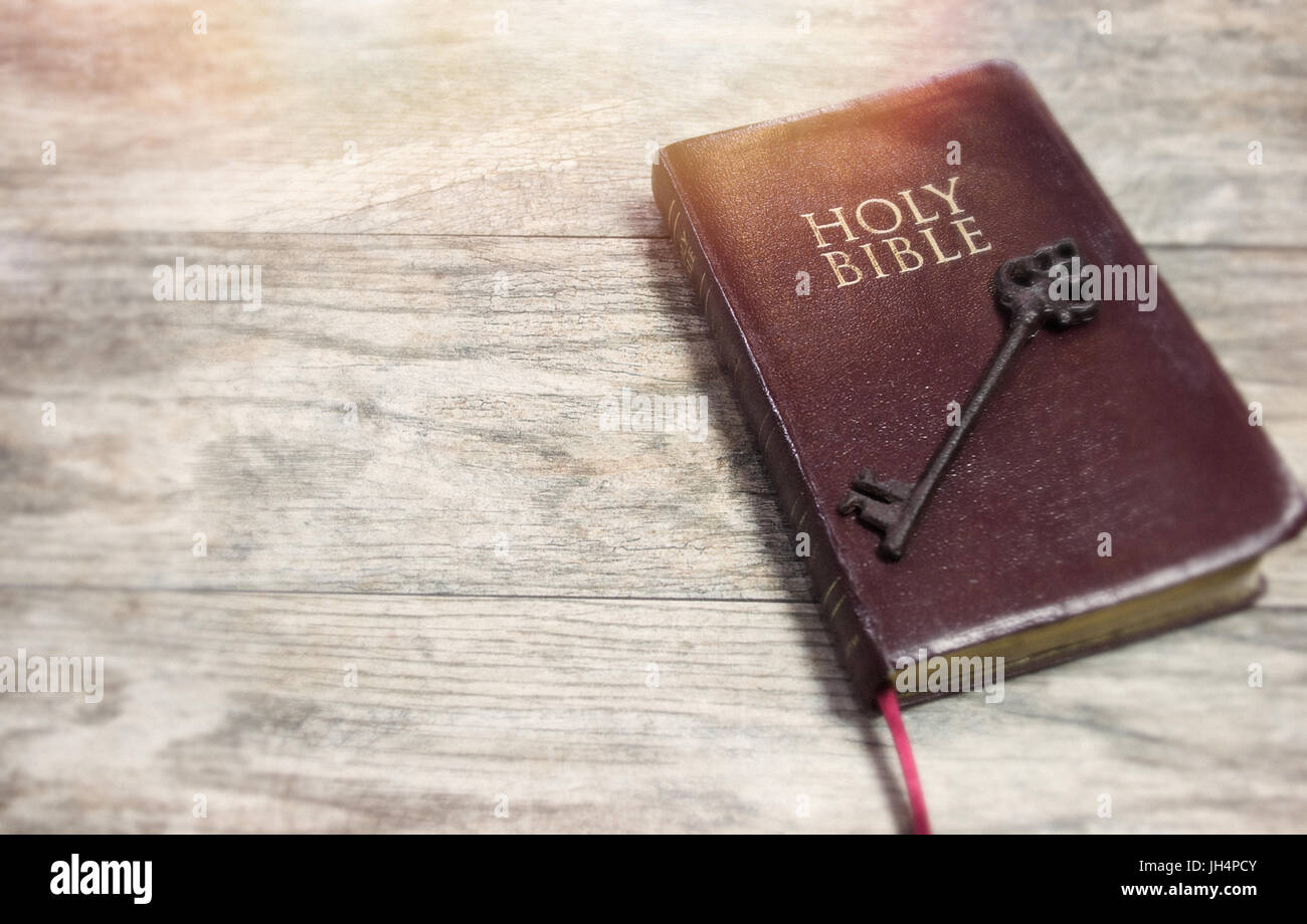 Antique key on Holy Bible against wood background - light glow Stock ...