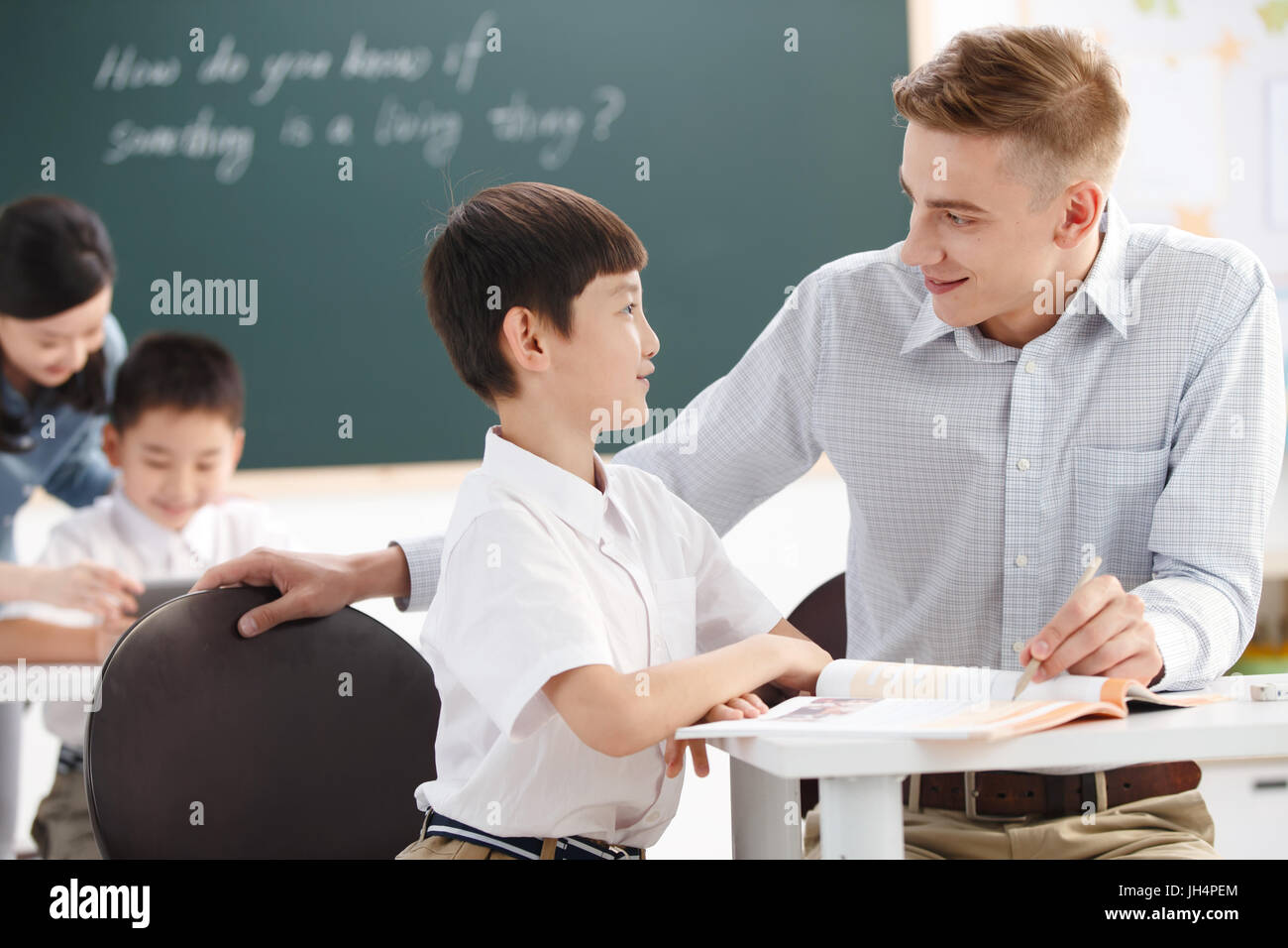 Male teacher helping student study Stock Photo - Alamy