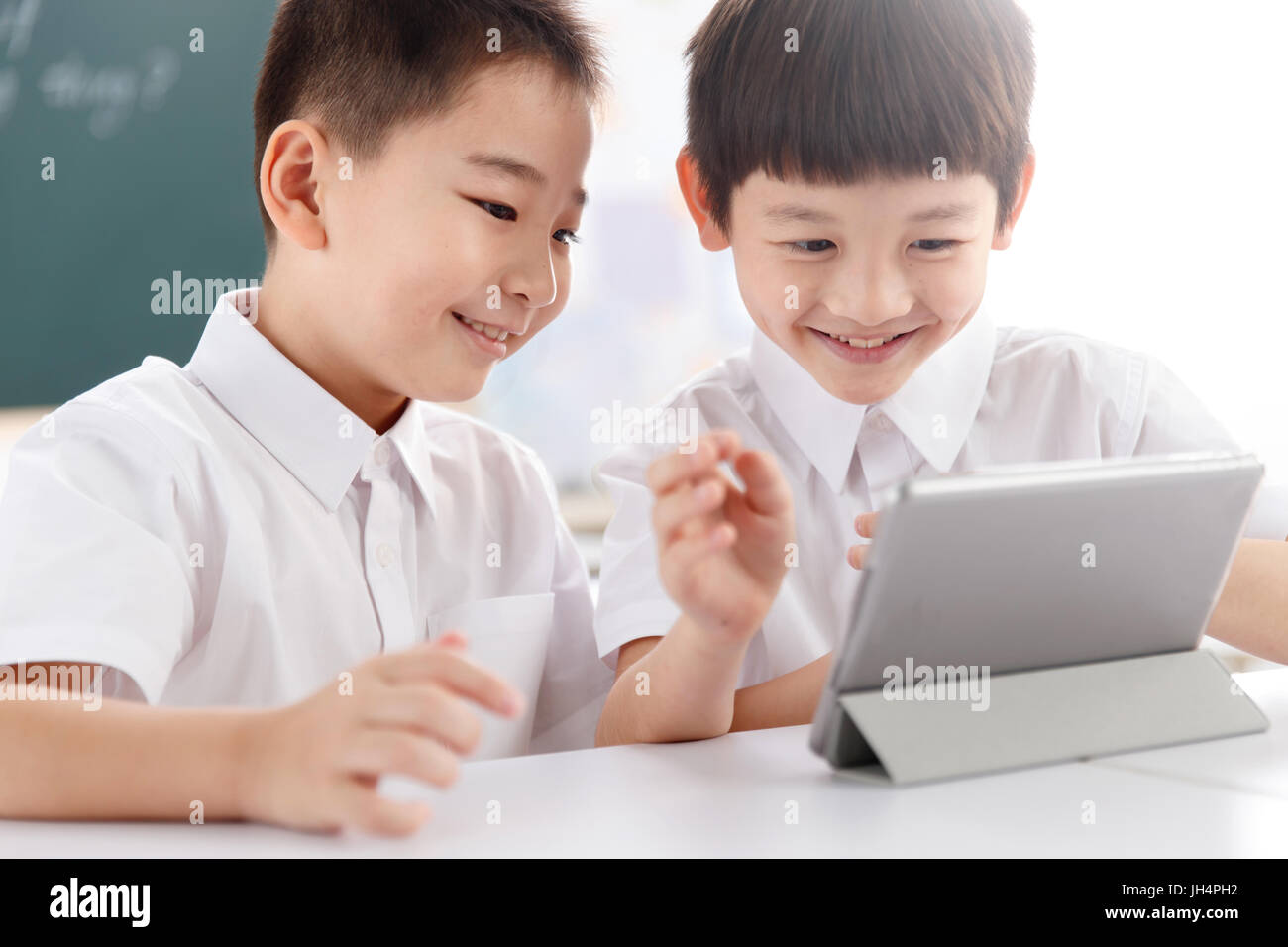 Two students using digital tablet in classroom Stock Photo - Alamy