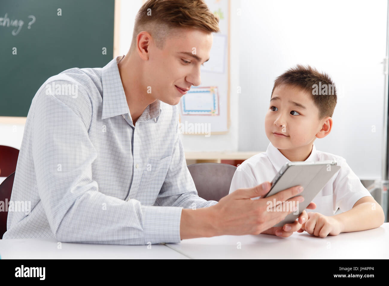Male teacher helping student study Stock Photo - Alamy
