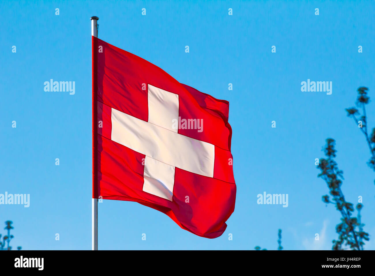 Swiss Confederation, Switzerland national flag waving on blue sky ...