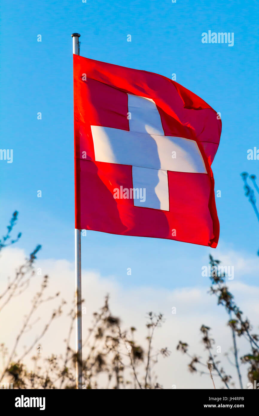 Swiss Confederation, Switzerland national flag waving on blue sky ...