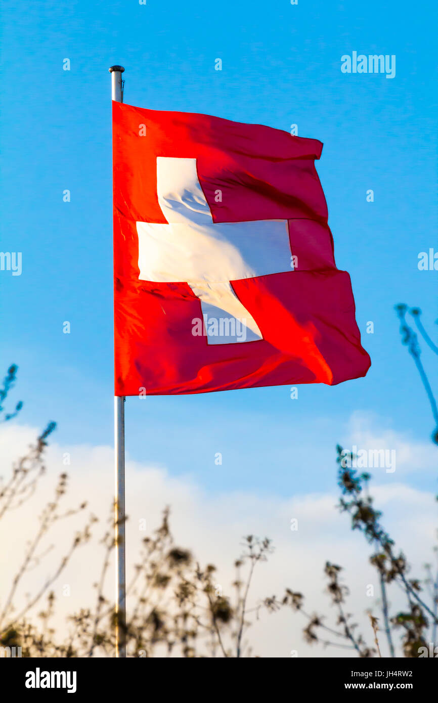 Swiss Confederation, Switzerland national flag waving on blue sky ...
