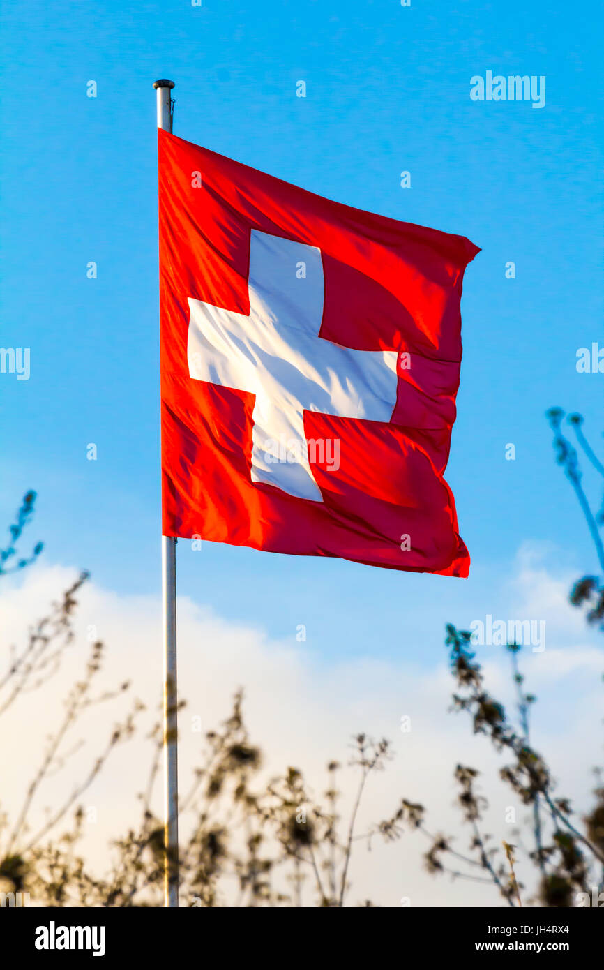 Swiss Confederation, Switzerland national flag waving on blue sky ...