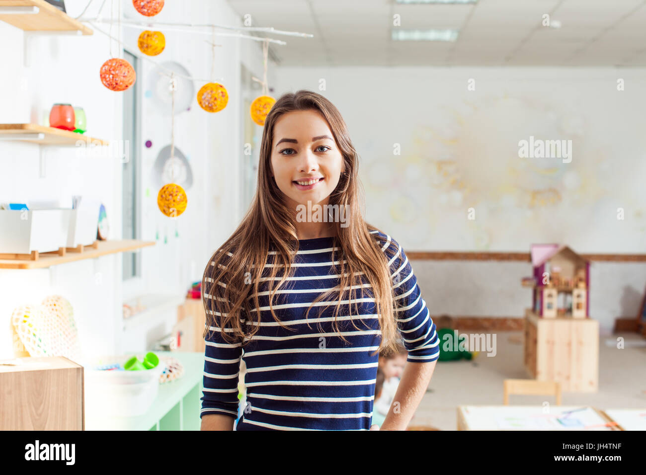 Smiling young preschool teacher in a Waldorf kindergarten Stock Photo ...