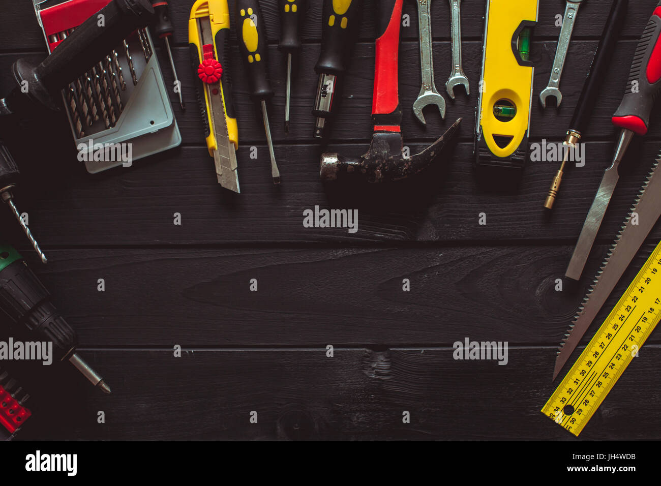 A set of tools laid out in a semicircle on top of the wooden table with ...