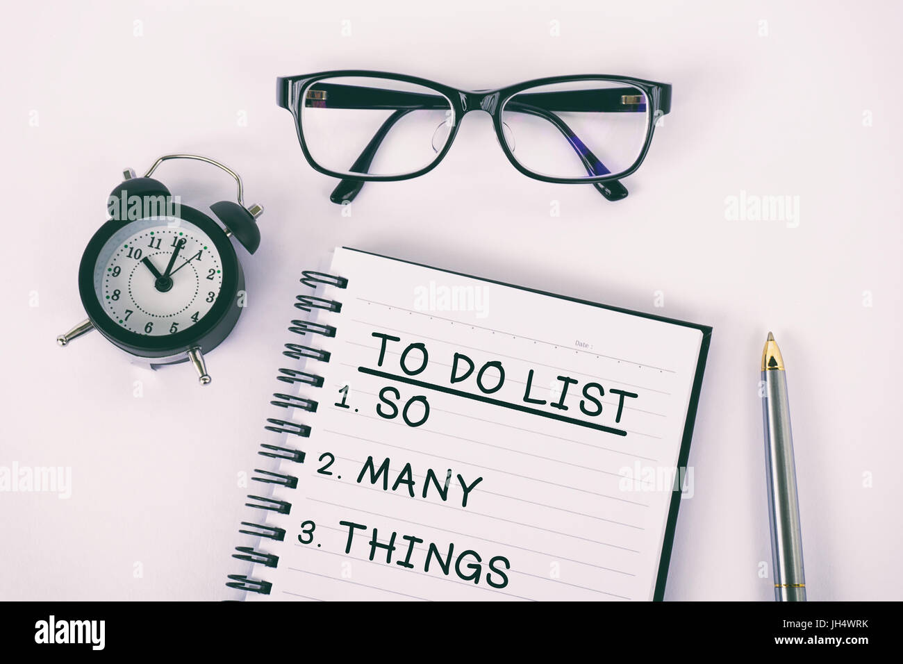 To do list written on a notepad with eyeglasses, pen and alarm clock ...
