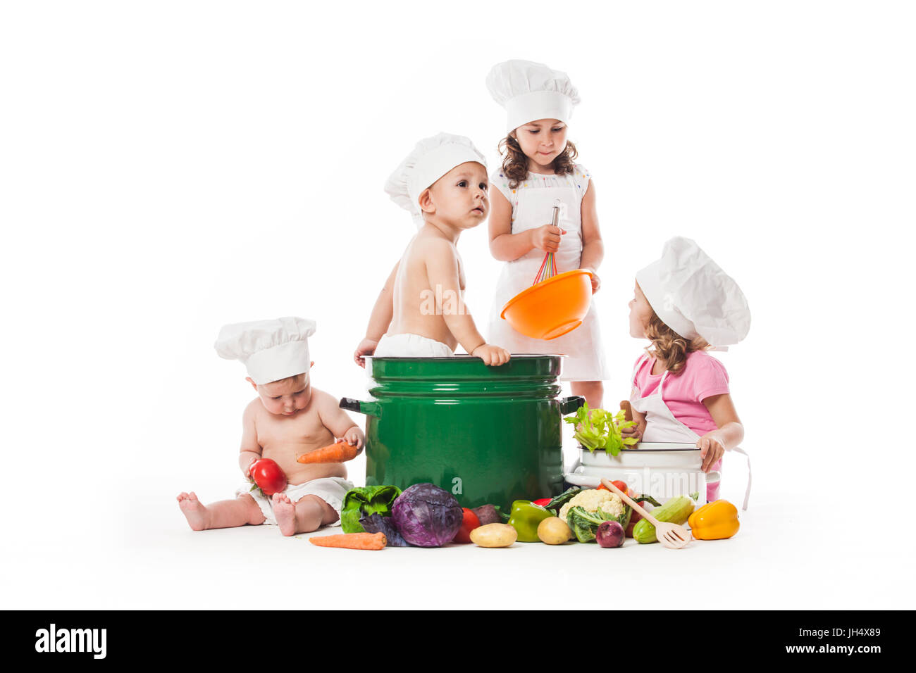 Group of kids play and cook with vegetables. Little chefs isolated on ...