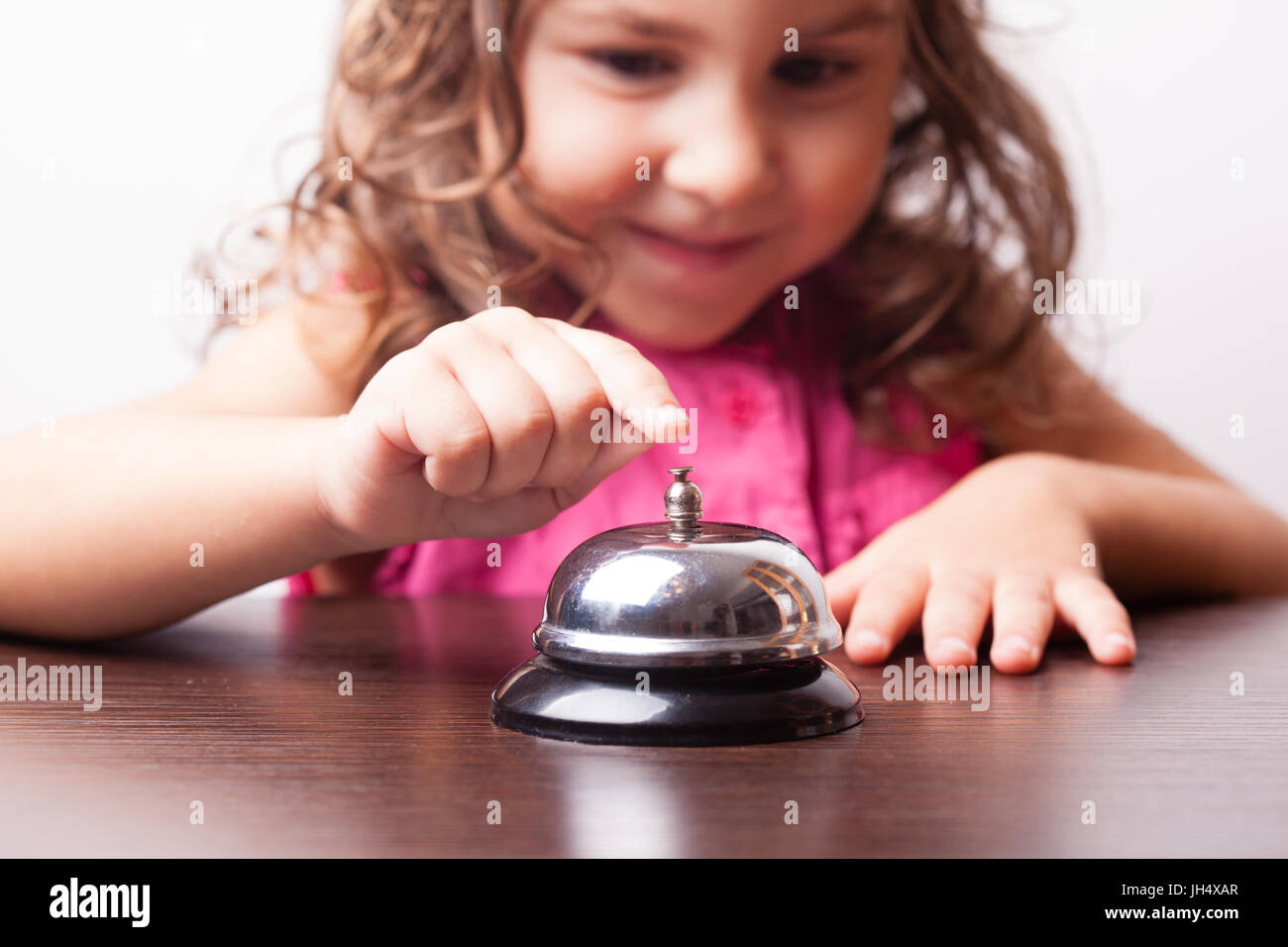 Little pretty girl push on the bell, board game on time Stock Photo - Alamy