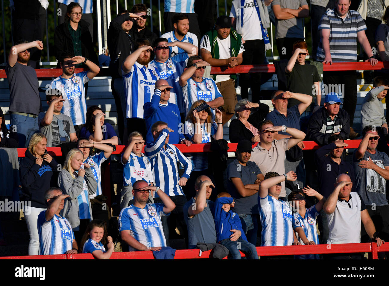 Fans shield their faces from the setting sun during the pre-season ...