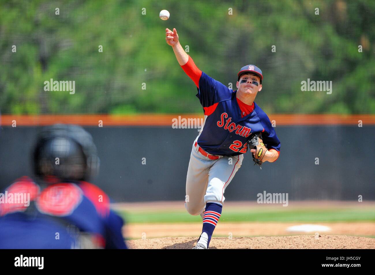 Pitcher delivering a pitch to an opposing hitter during a high school ...
