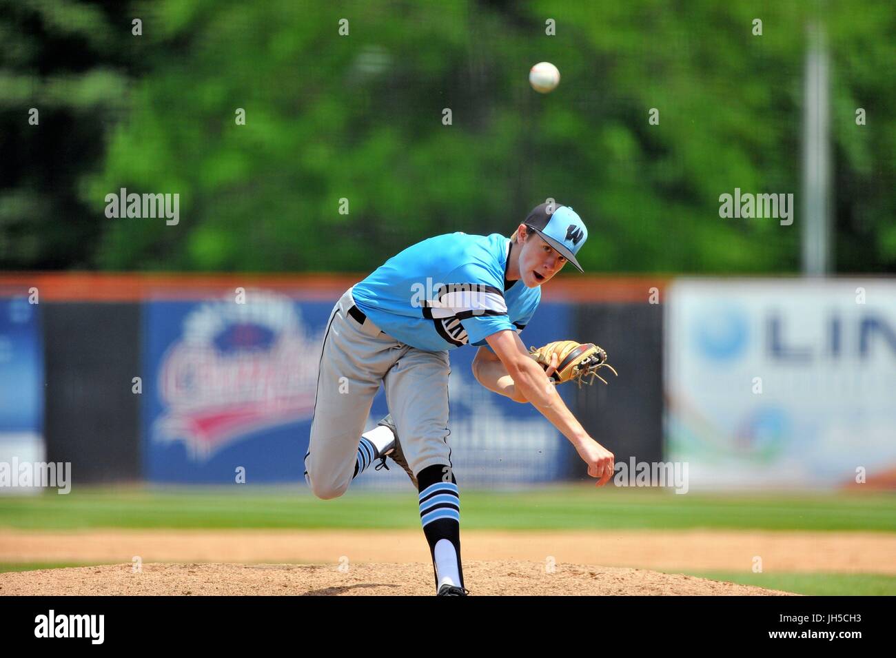 Pitcher delivering a pitch to an opposing hitter during a high school ...