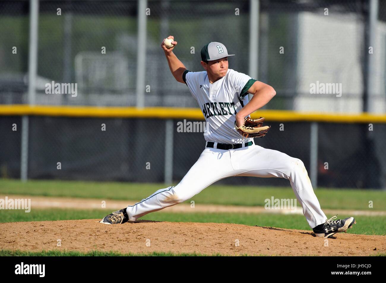 Pitcher delivering a pitch to an opposing hitter during a high school ...