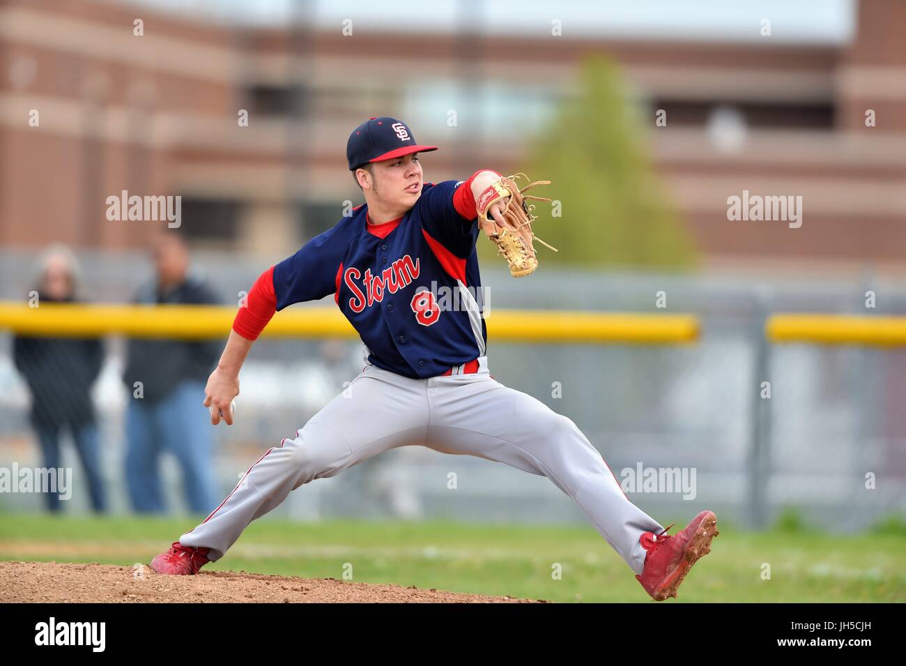 Pitcher delivering a pitch to an opposing hitter during a high school ...