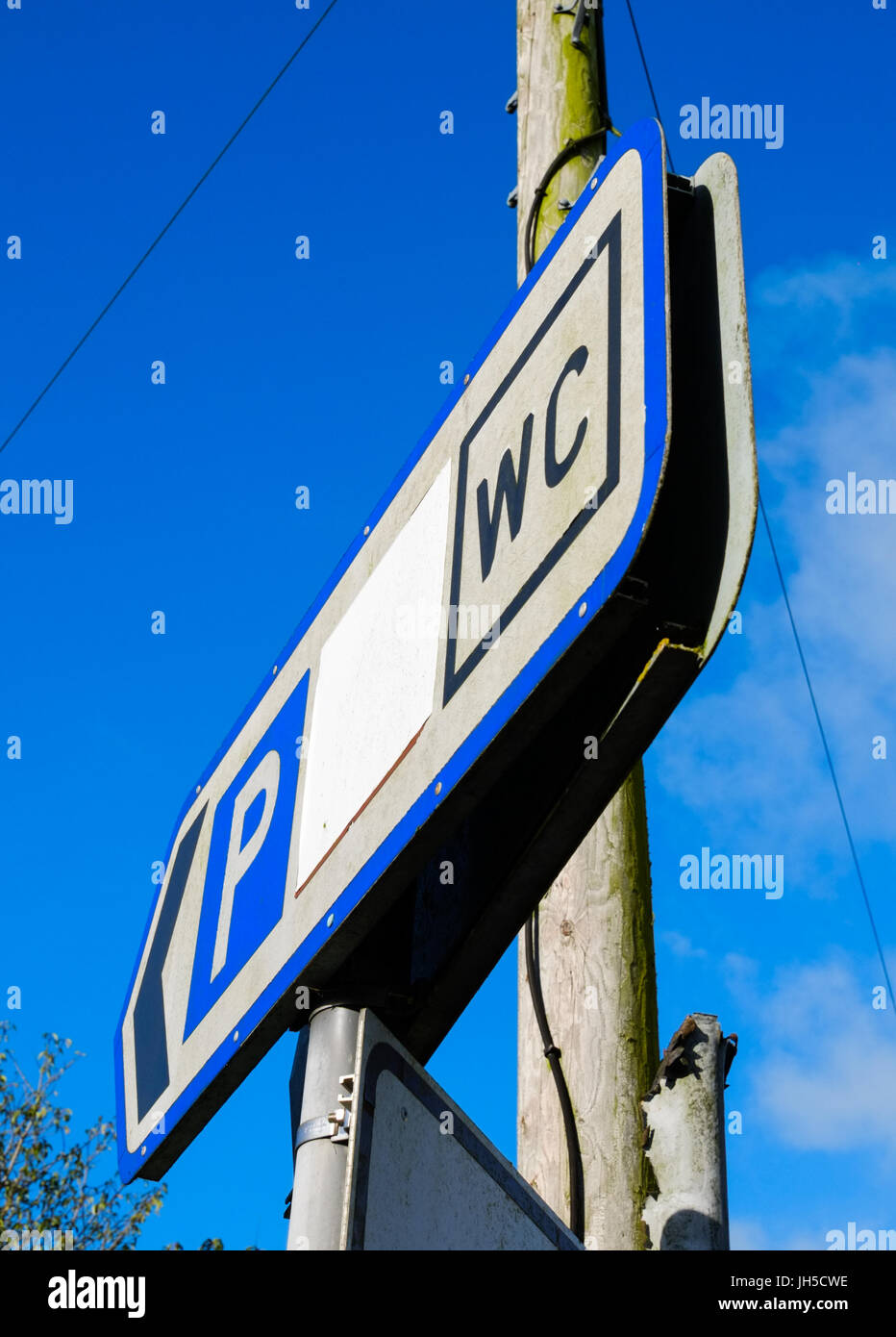Information road sign indicating vehicle parking and public toilets ...