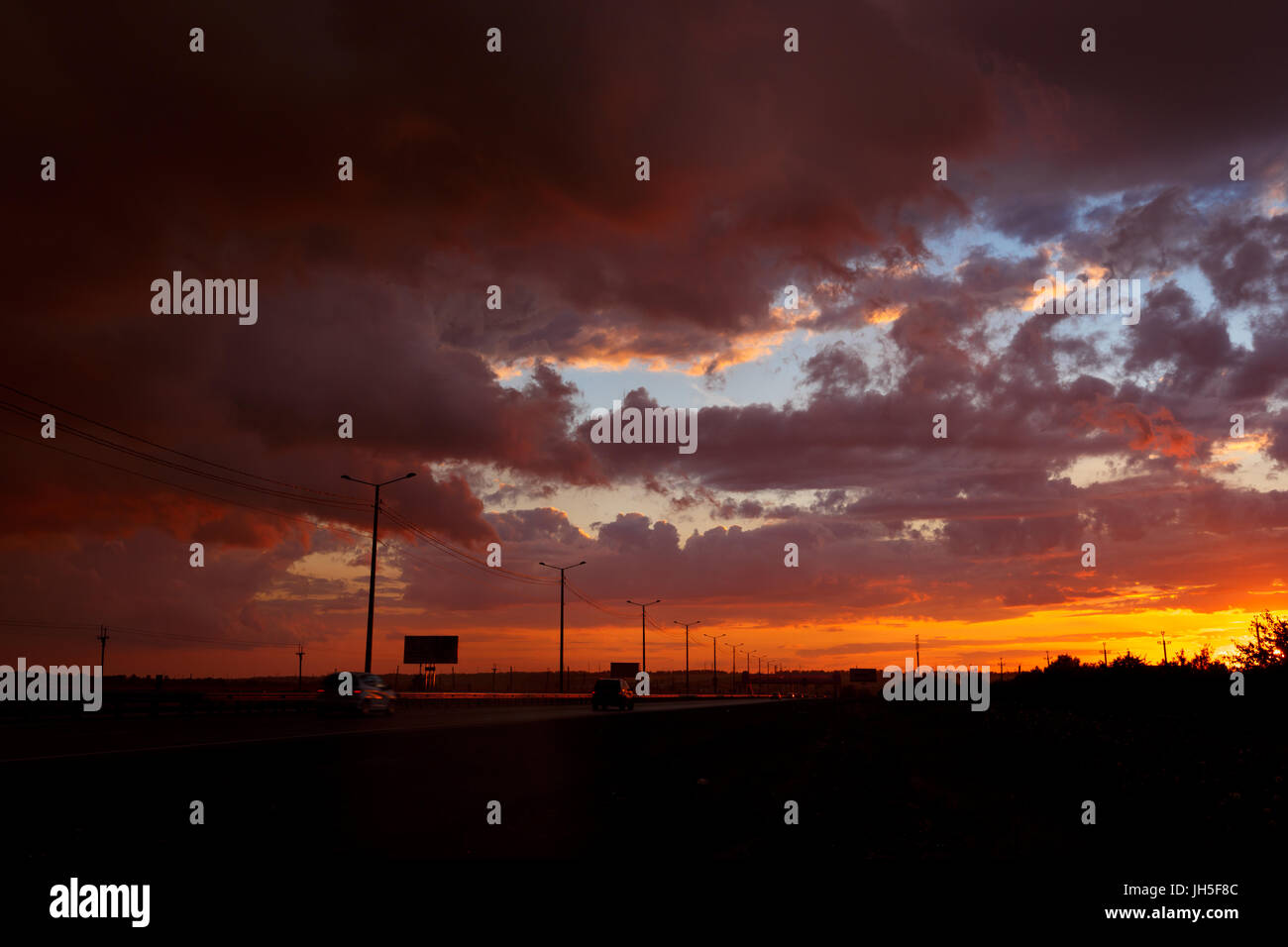 Beautiful sunset landscape with cars on the road Stock Photo - Alamy