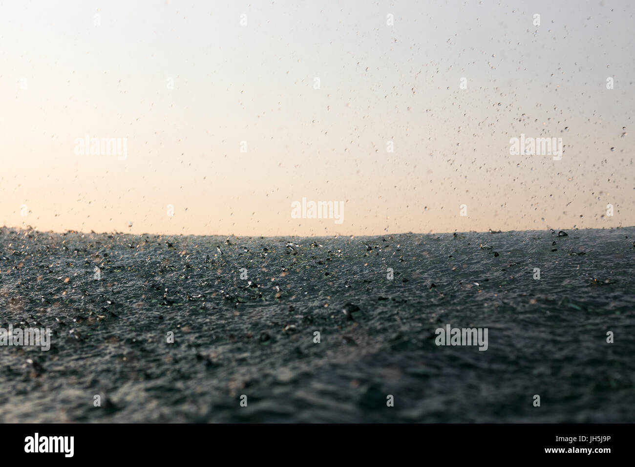 Ocean spray from a passing wave lands on the water surface in small ...