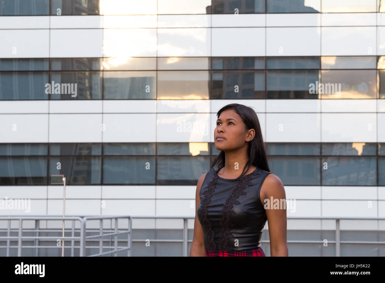 Charming girl is looking up. Urban and architectural background, city ...
