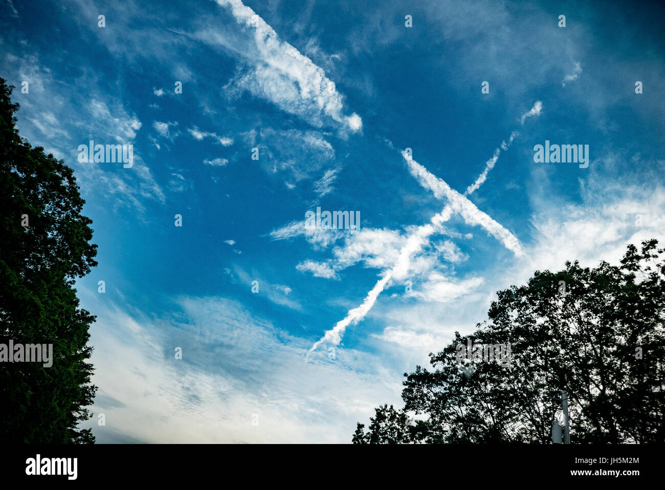 two contrails cross in the evening sky creating a dramatic "cross Stock ...