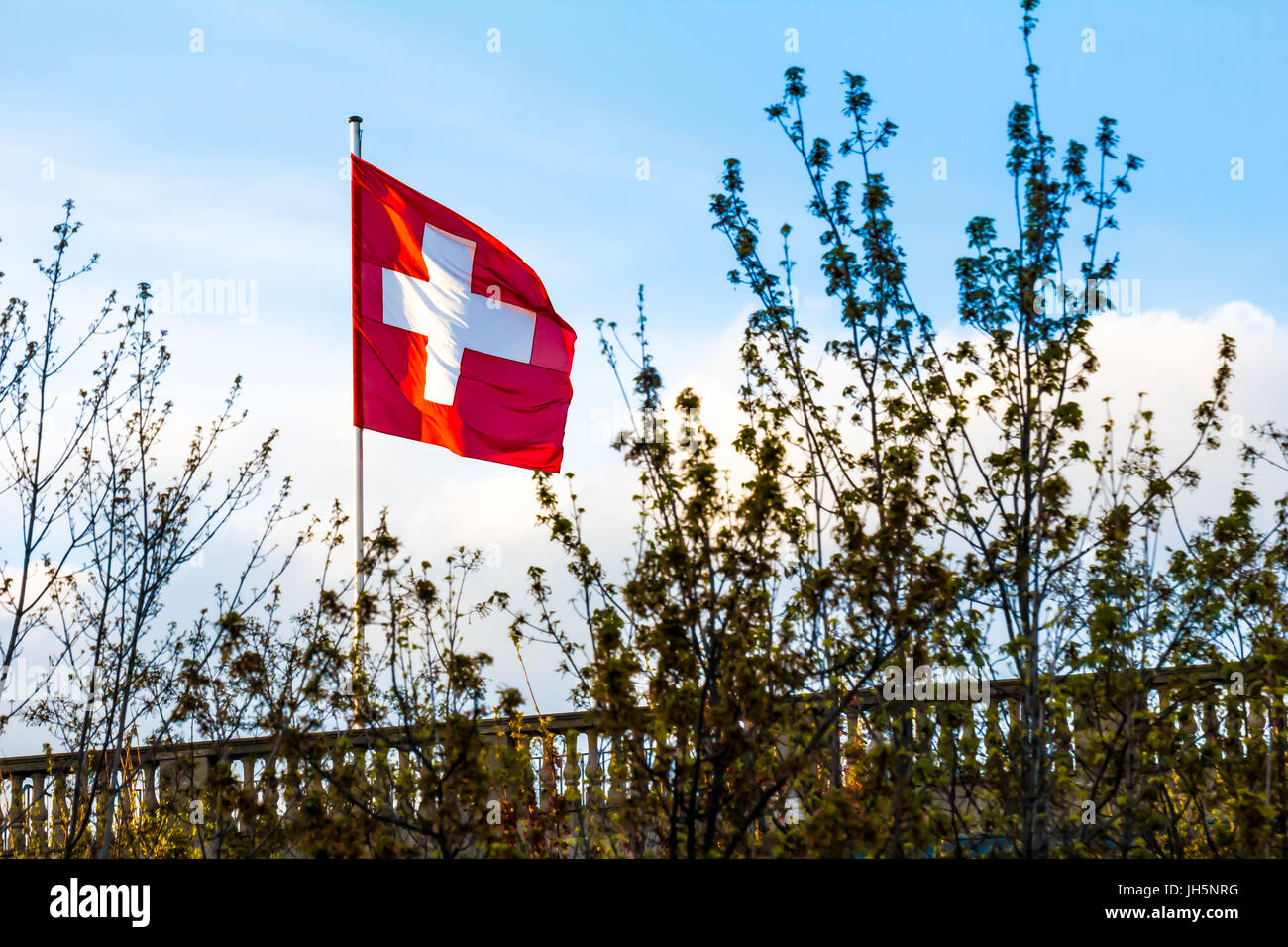 Swiss Confederation, Switzerland national flag waving on blue sky ...