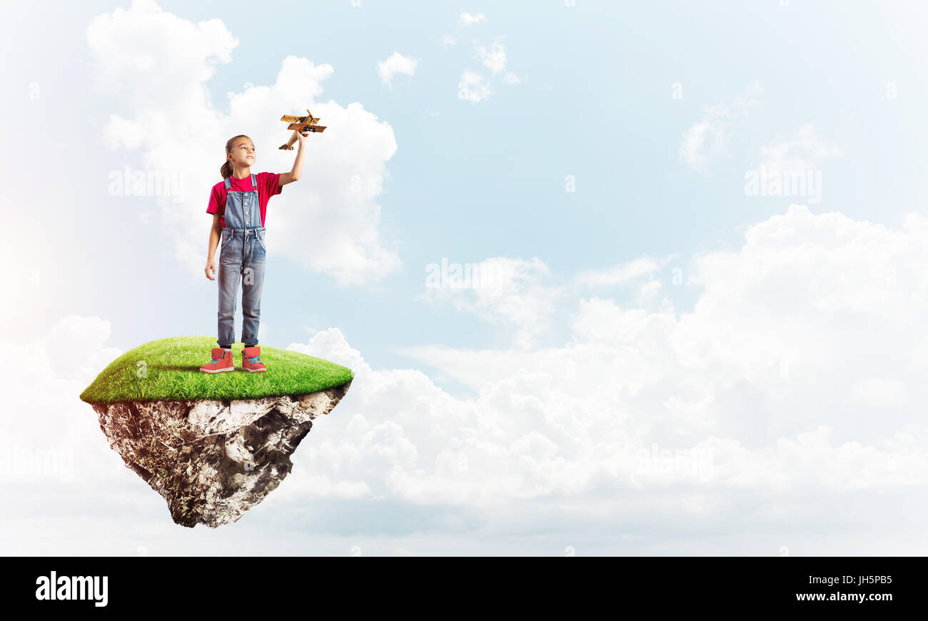 Concept of careless happy childhood with girl playing with airplane ...