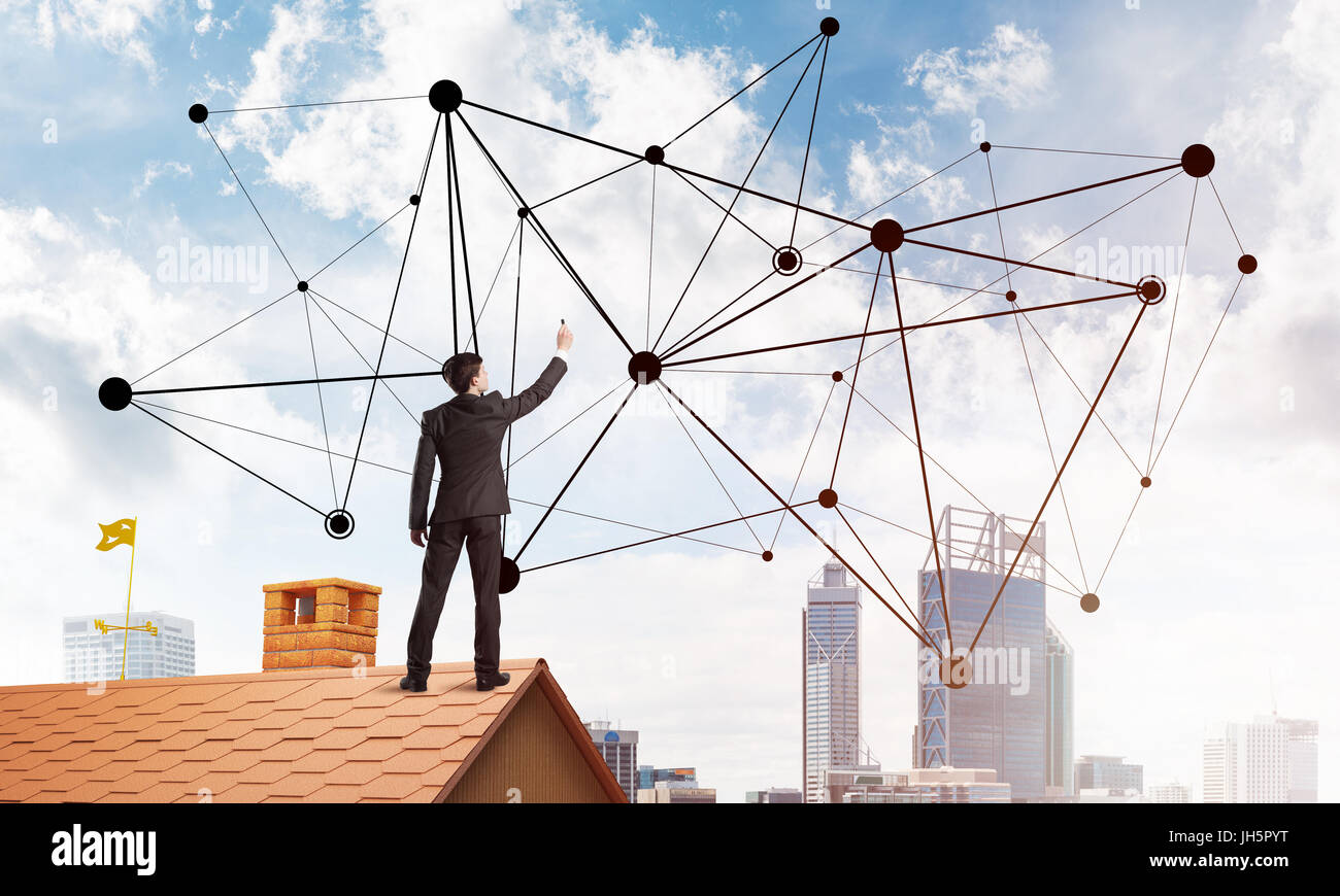 Businessman on house roof presenting networking and connection concept ...