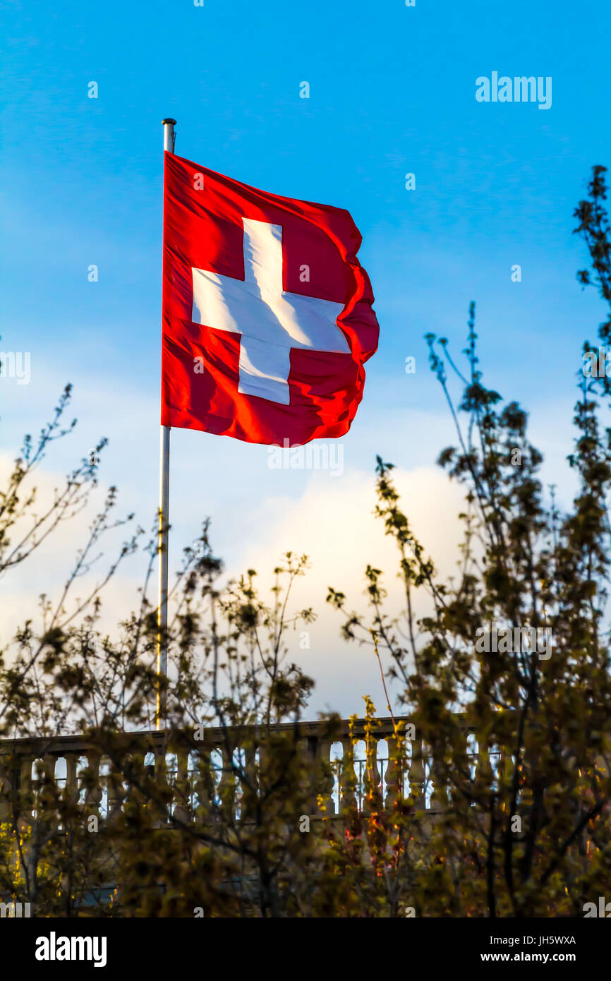 Swiss Confederation, Switzerland national flag waving on blue sky ...