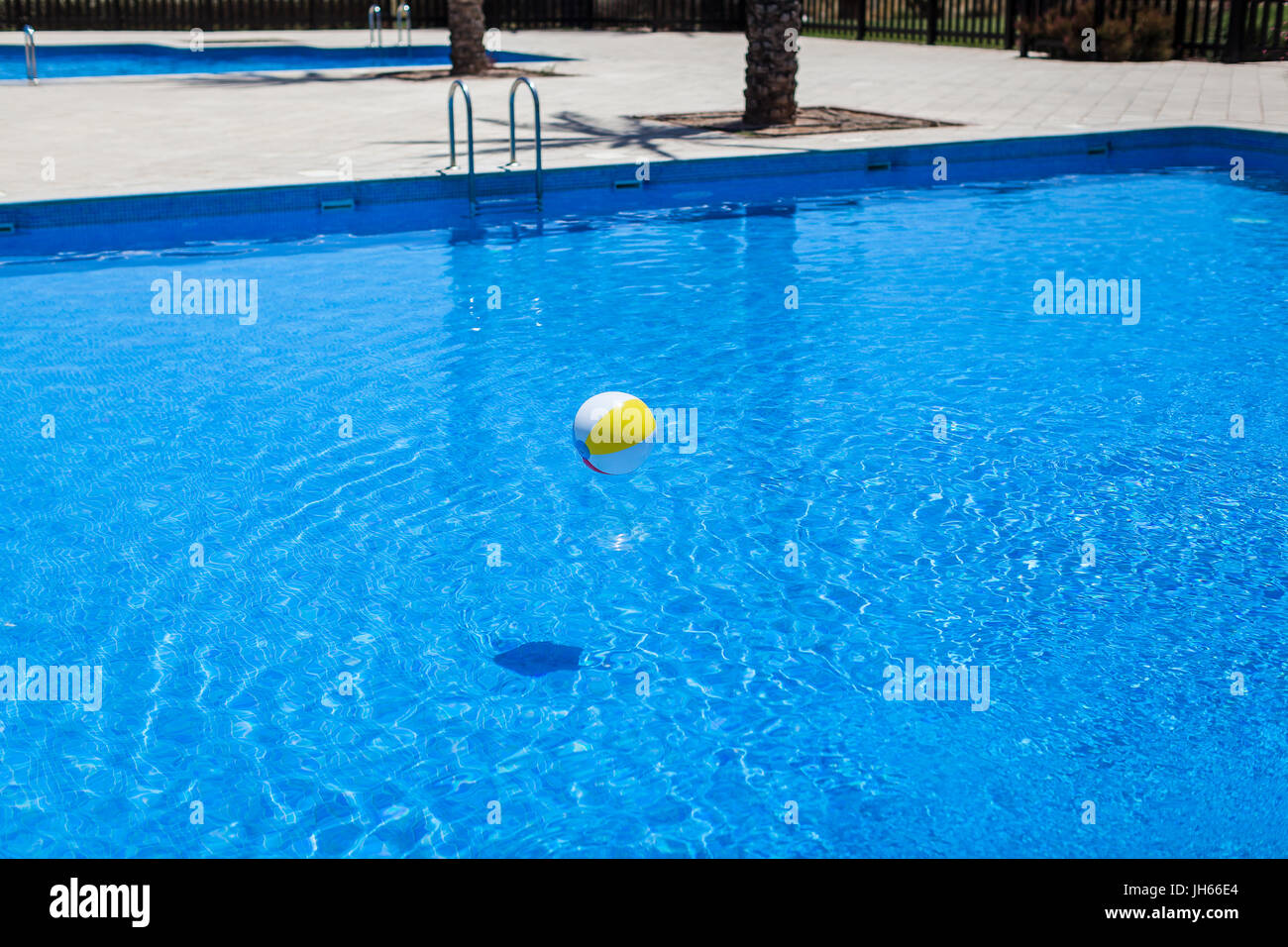 Inflatable beach ball floating in an outdoor swimming pool Stock Photo ...